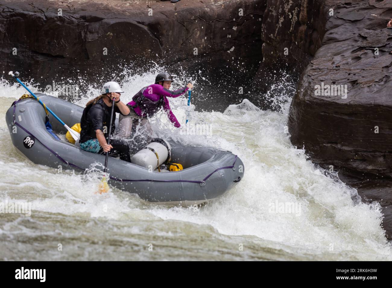 A group of people in a kayak navigating through the choppy waters of a ...