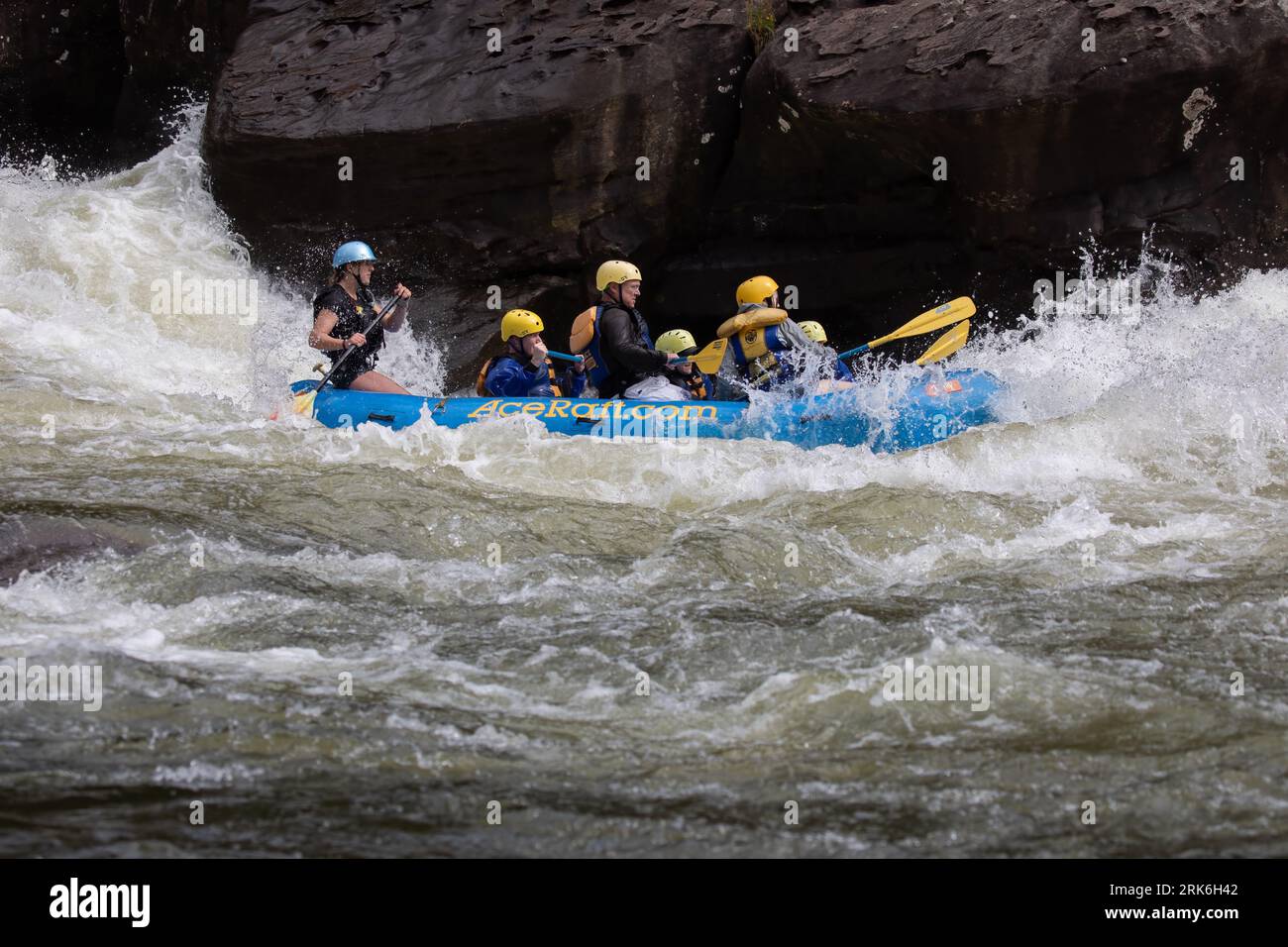 A group of people in a kayak navigating through the choppy waters of a ...