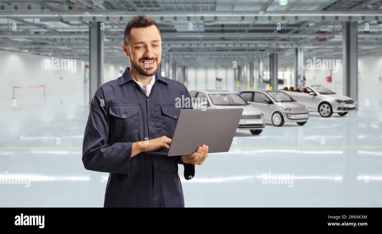 Car mechanic using a laptop computer inside a garage Stock Photo - Alamy