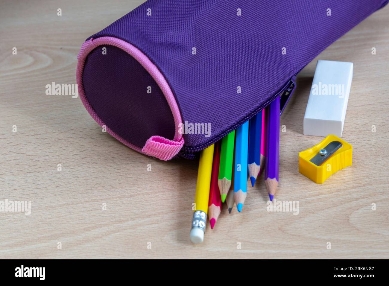 purple pencil case with colored paints and other school supplies on ...