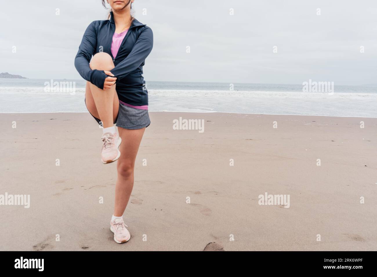 A young woman with a disabled hand performing a stretching exercise ...