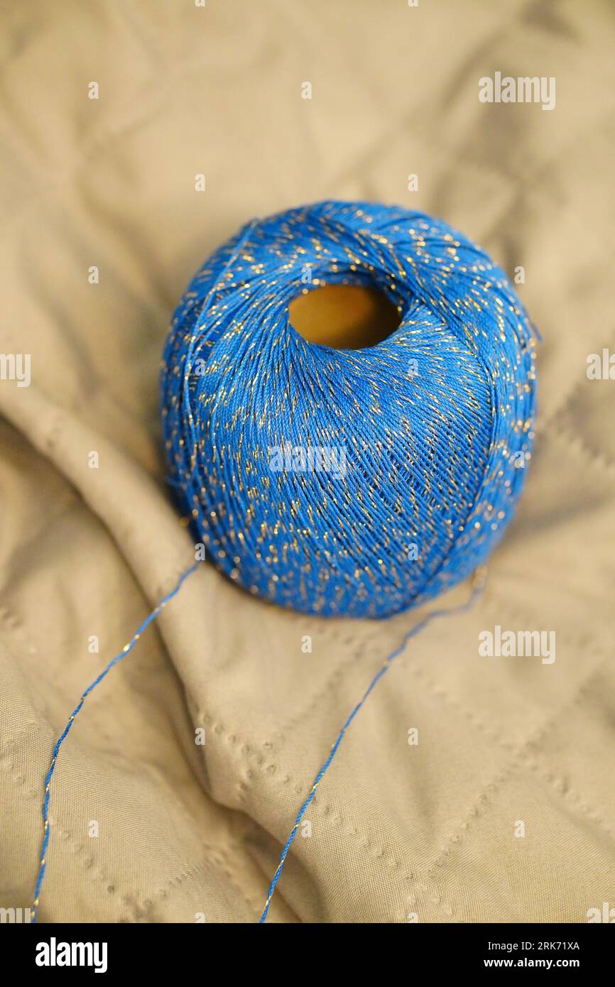 Blue thread with golden spots on a sheet Stock Photo - Alamy