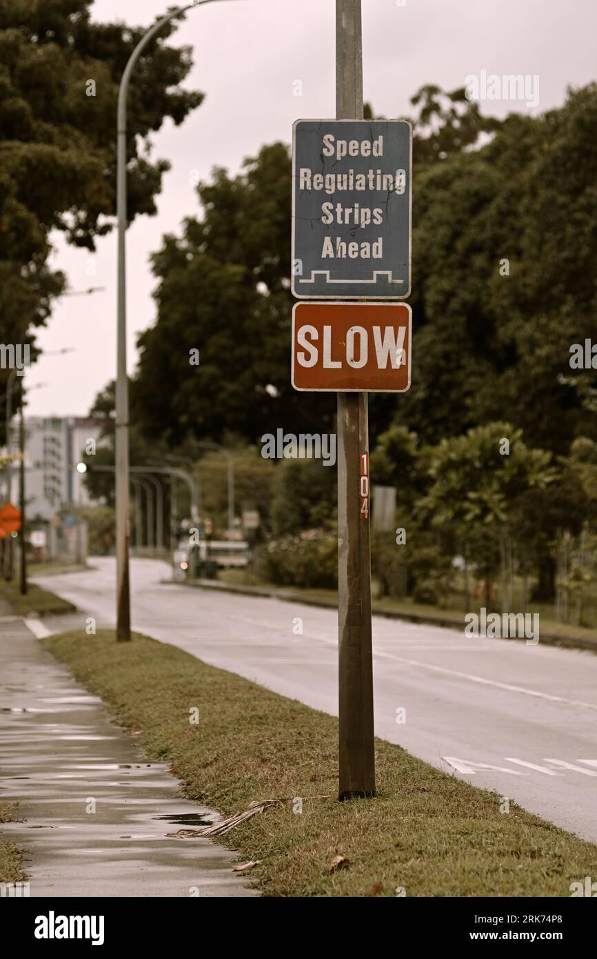 A vertical shot of a speed regulating strips ahead warning sign on a ...