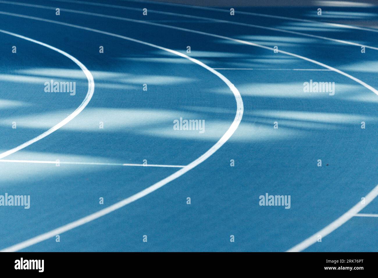 A blue running track with crisp white lines Stock Photo - Alamy