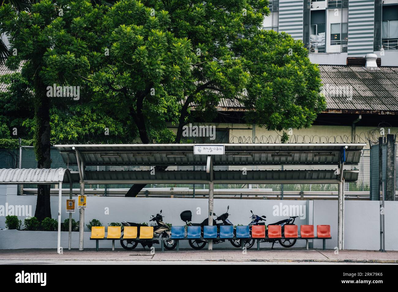 A busy bus station with vibrant colored seats and several motorcycles ...