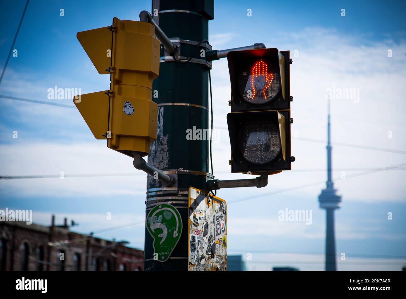 An illuminated stop signal mounted on a black metal pole outside a ...