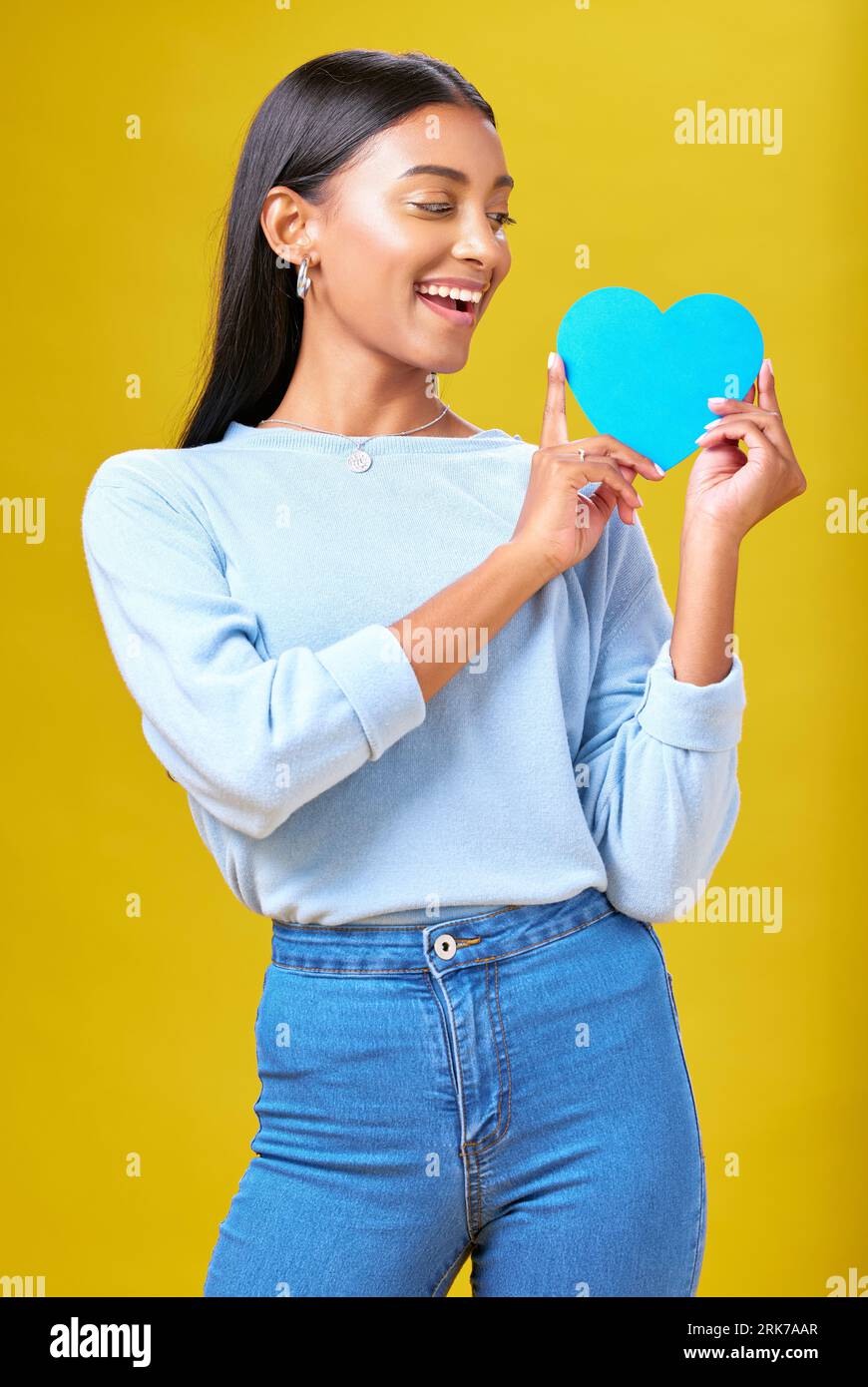 Donation, smile and woman with blue heart in studio for help, hope or ...