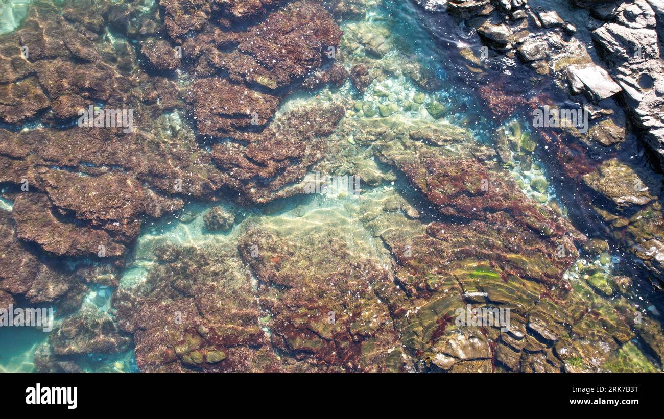 A beautiful landscape of a clear body of water surrounded by rocks and ...