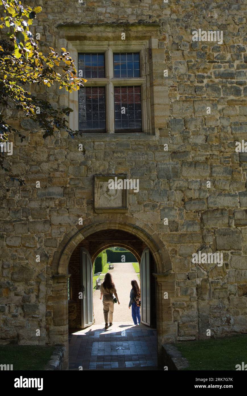 woman visitors walking past the gate house in Penshurst Place Manor ...