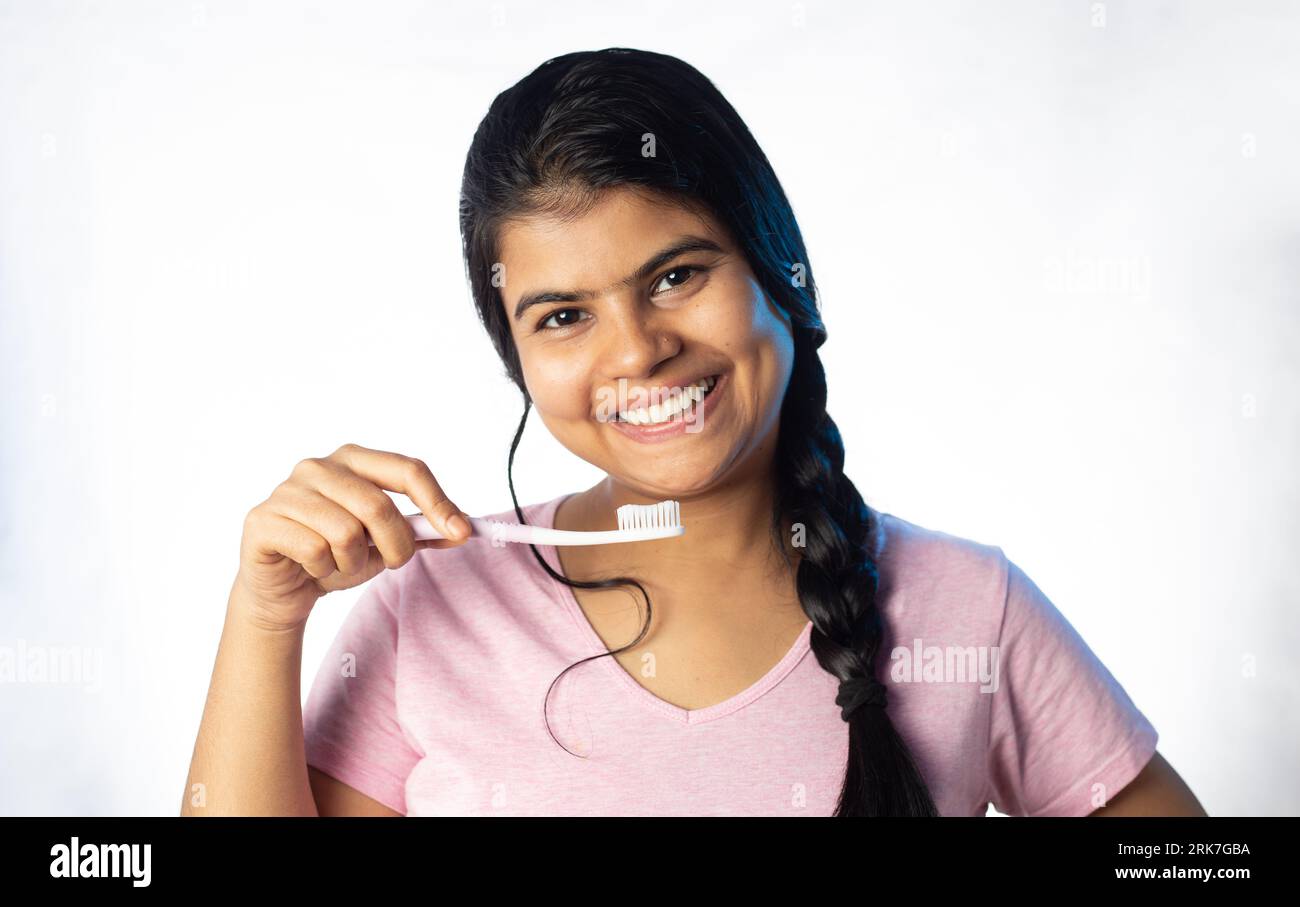 An Indian woman female girl brushing teeth on white background with ...