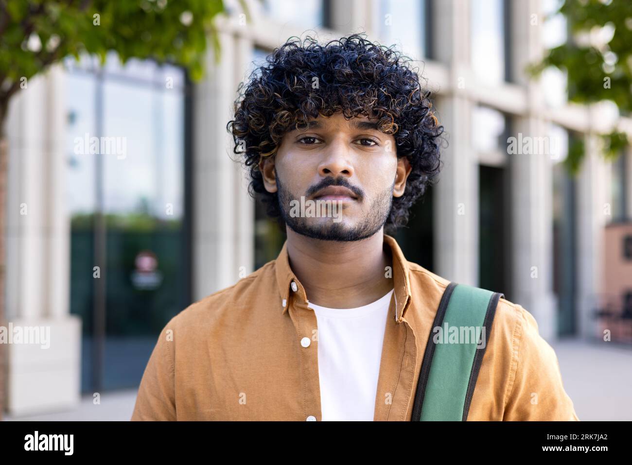 Close-up photo. Portrait of a young Indian male programmer, developer ...
