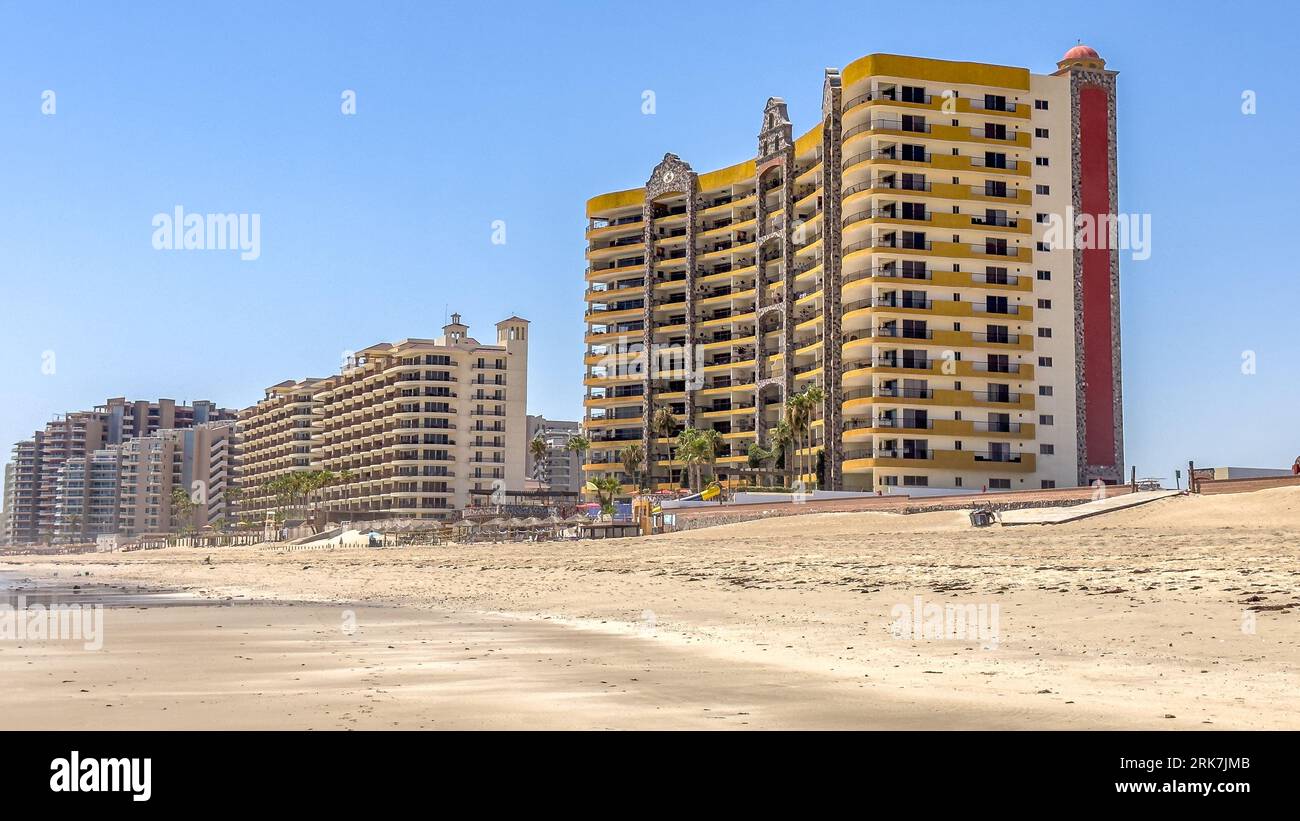 A scenic outdoor view of a beach area featuring two buildings on either ...
