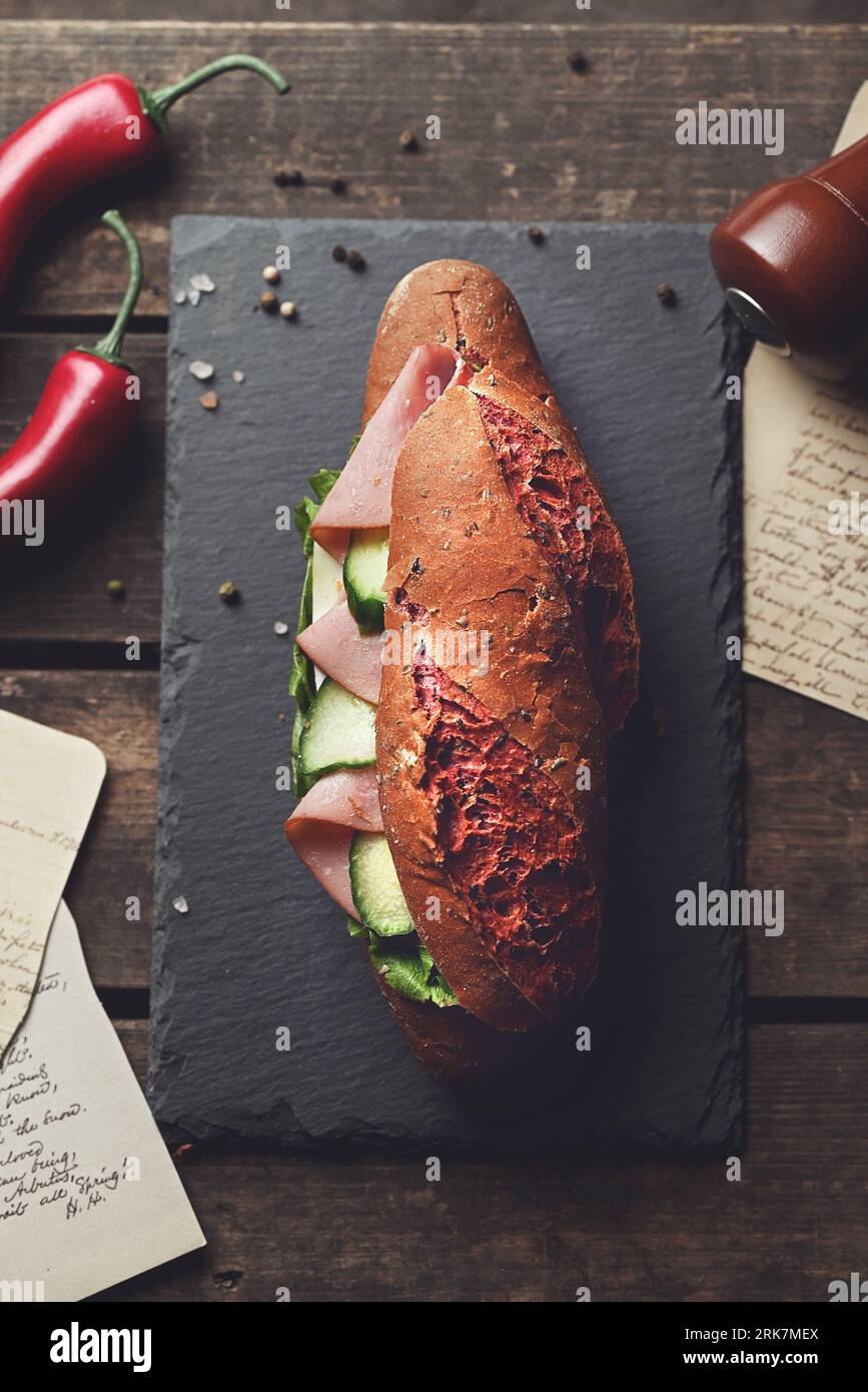 An overhead view of a cutting board with a freshly cooked sandwich ...