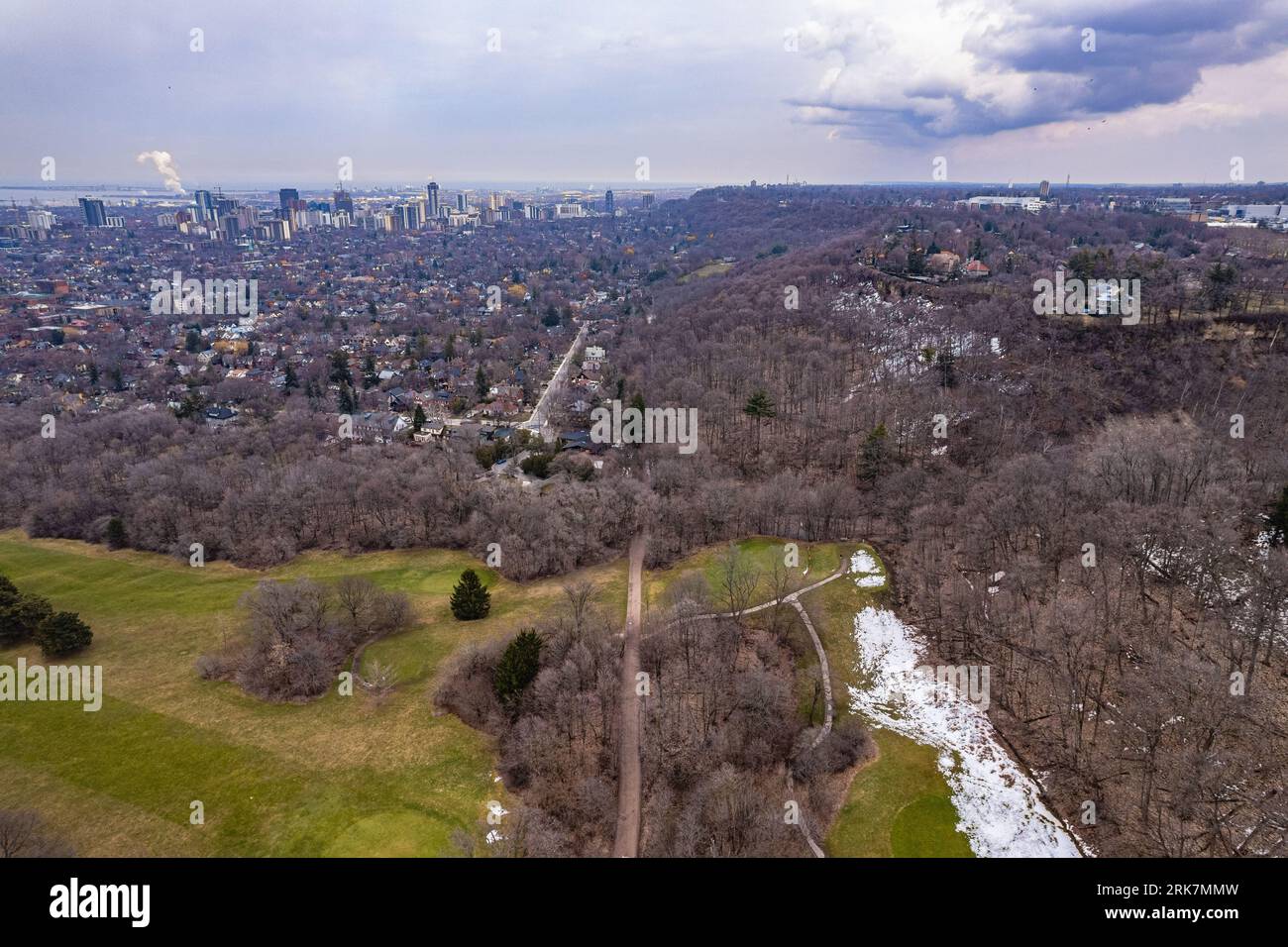 An aerial view of an expansive green field in a bustling urban area ...