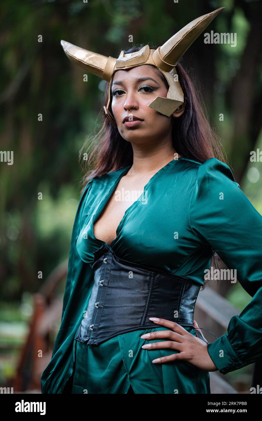 A young female cosplayer is dressed in a costume depicting Loki, a ...