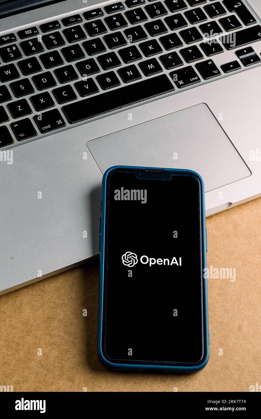 A vertical shot of a phone with an OpenAI logo on the screen on a ...