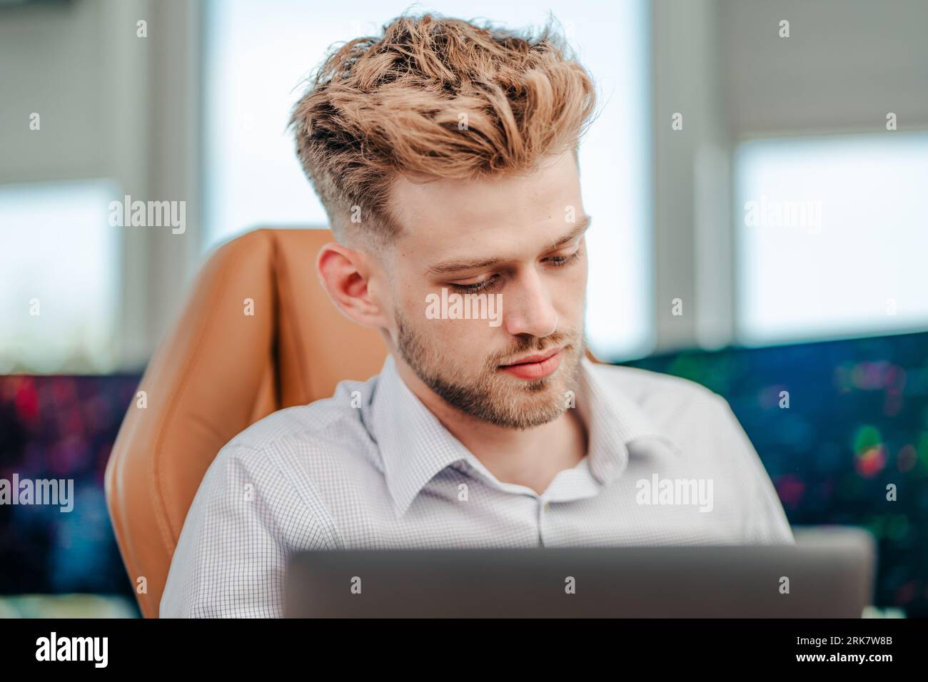 A successful business man is working diligently on a laptop computer ...