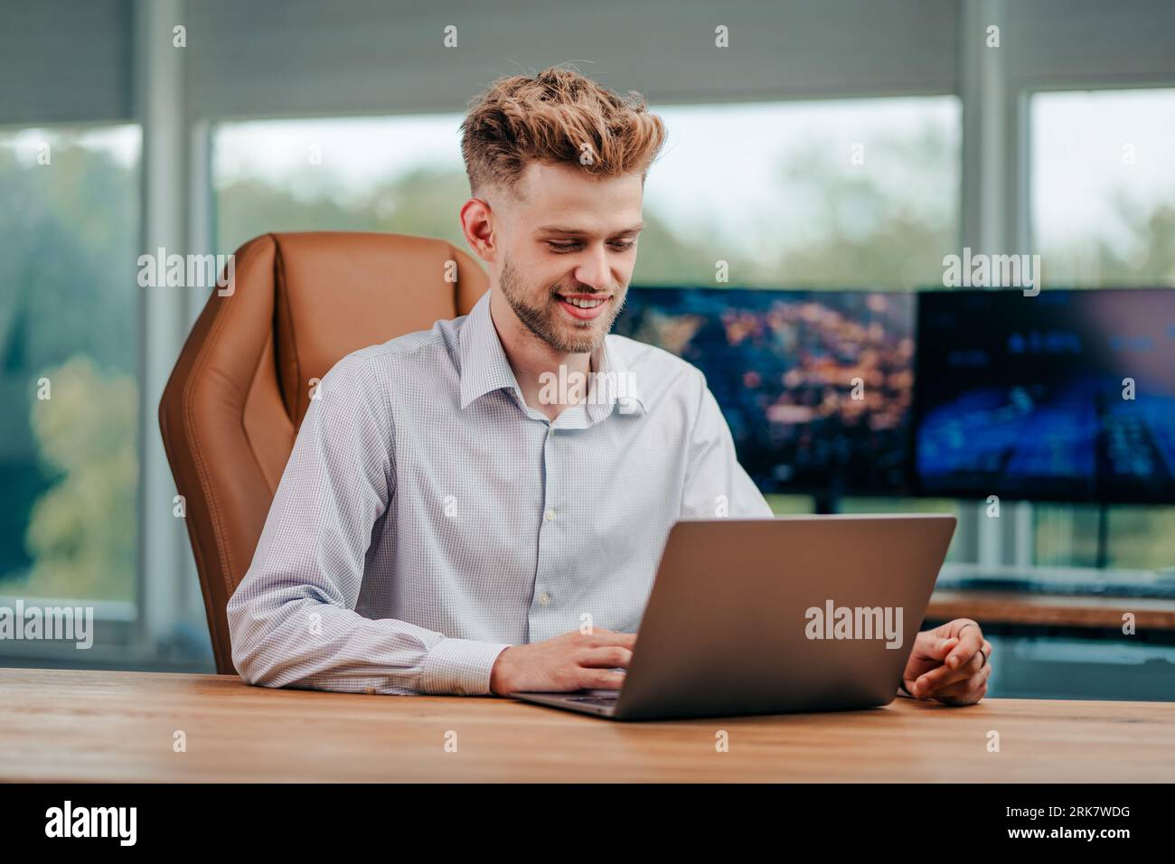 A successful business man is working diligently on a laptop computer ...