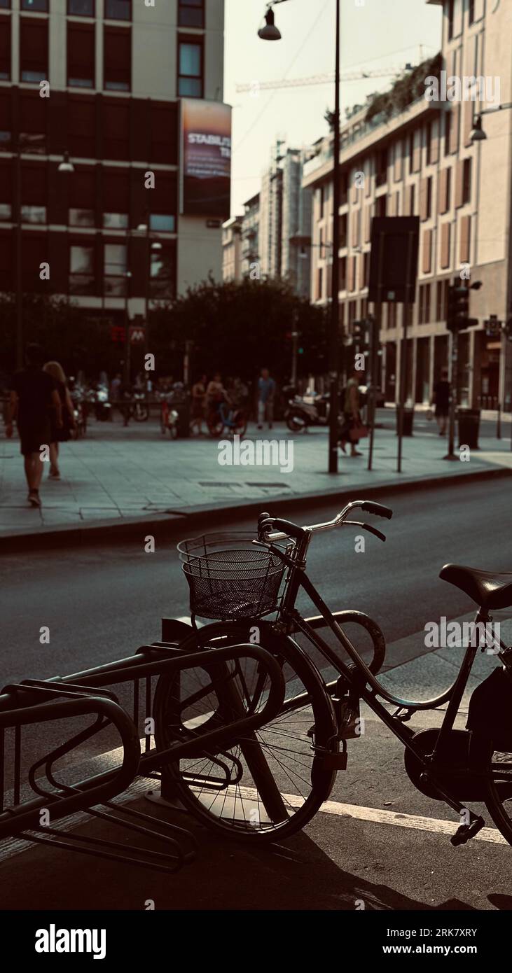A line of bicycles parked neatly on the sidewalk along a busy city ...