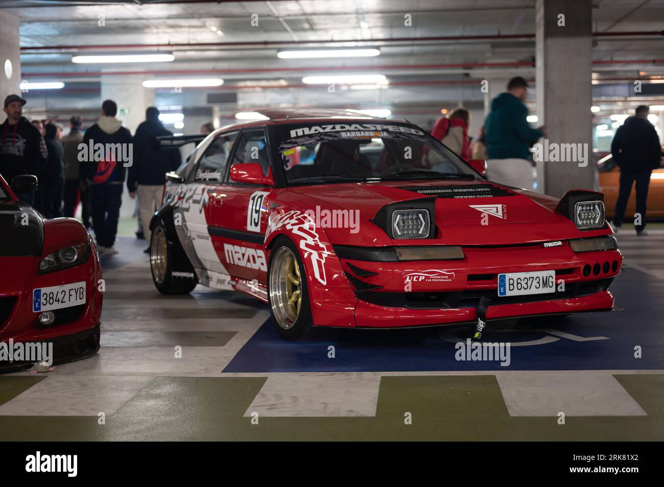 Front view of an old tuned red Mazda 323f BG 1989 with spoiler and ...