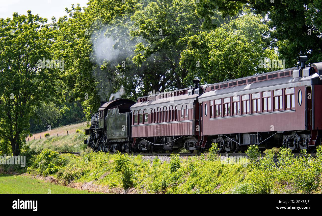 A vintage steam locomotive chugging along a picturesque railway track ...