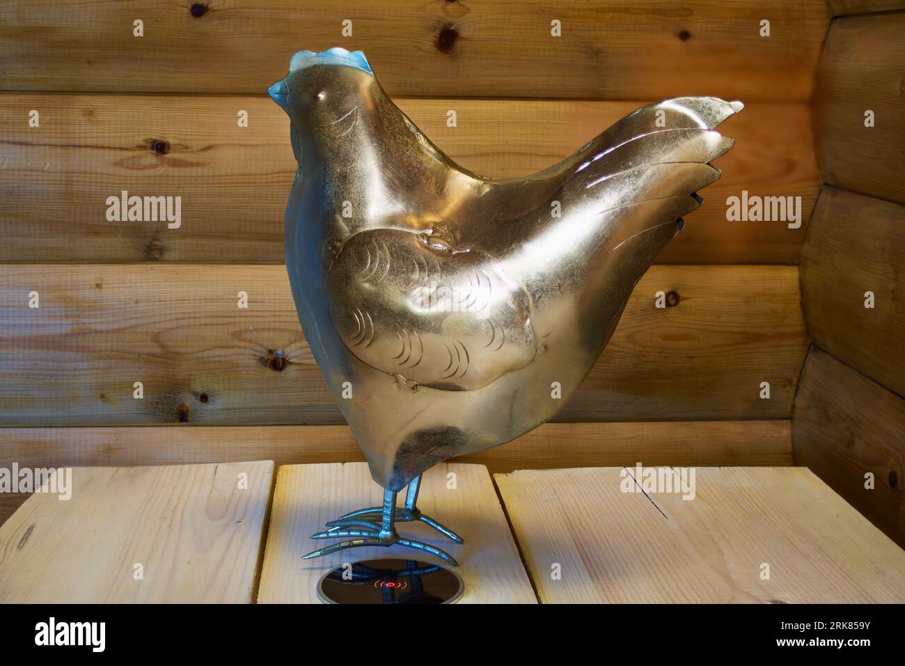 A vibrant golden chicken stands atop a wooden tabletop Stock Photo - Alamy