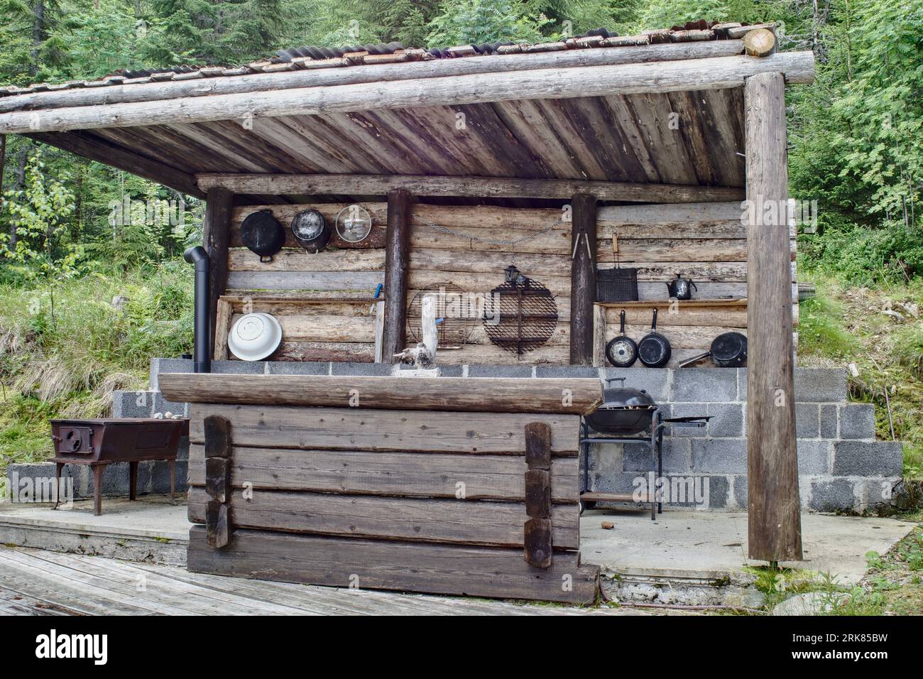 An aged wooden structure with a built-in outdoor kitchen providing a ...