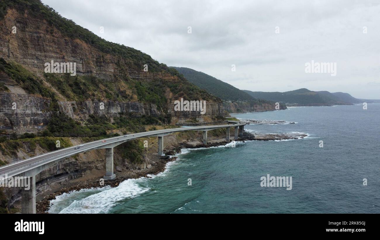 An aerial view of Sea Cliff Bridge crossing the Pacific Ocean near ...