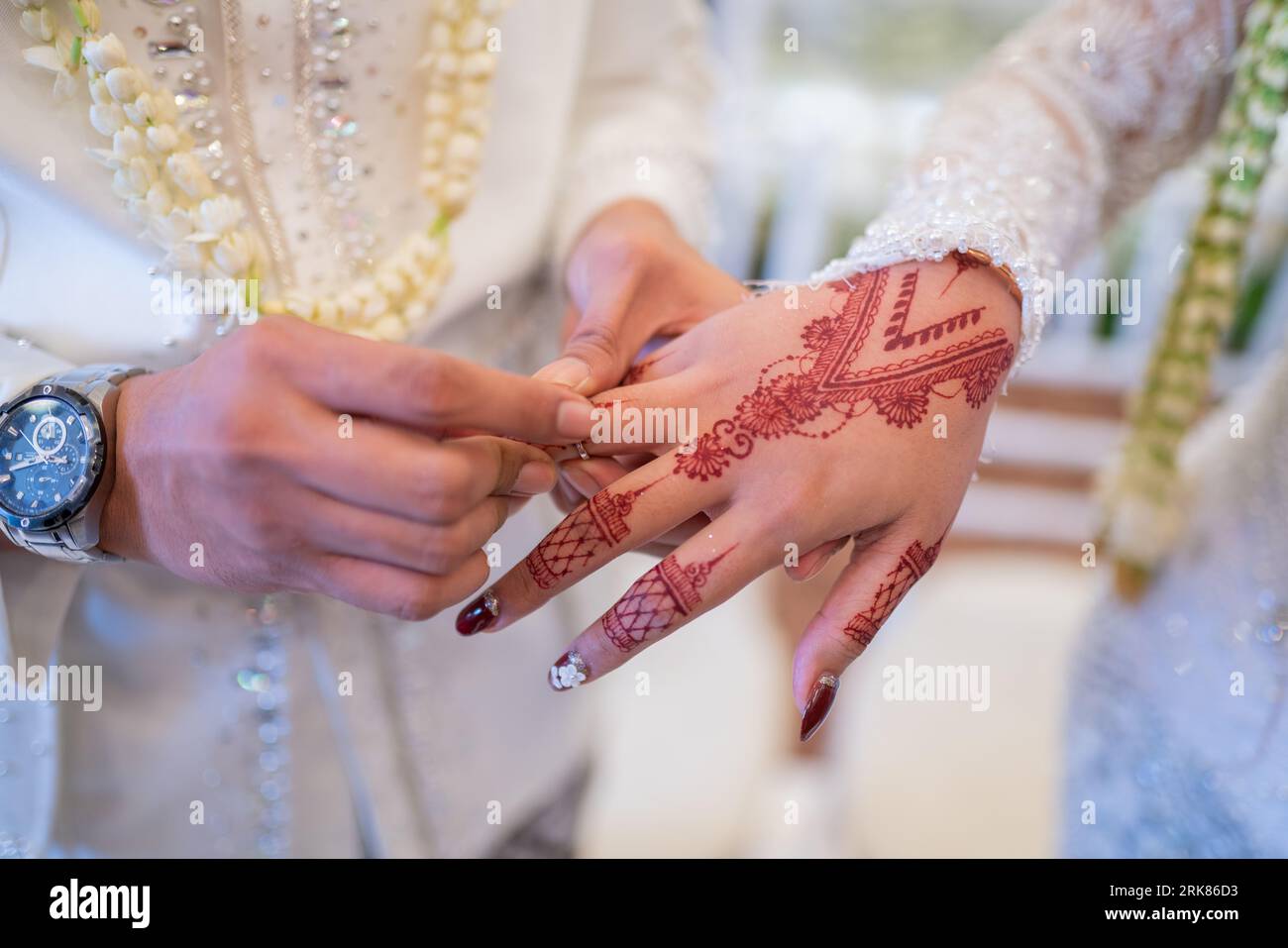 A husband and wife put each other's wedding rings in a traditional ...