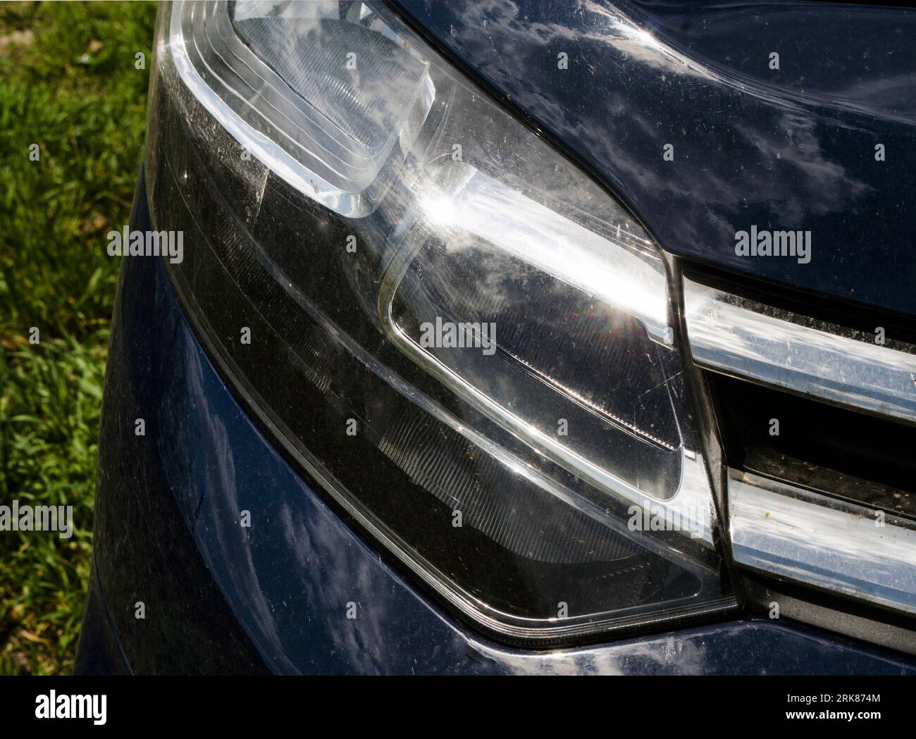 Modern car headlights with sky reflection on them. Car headlight close ...