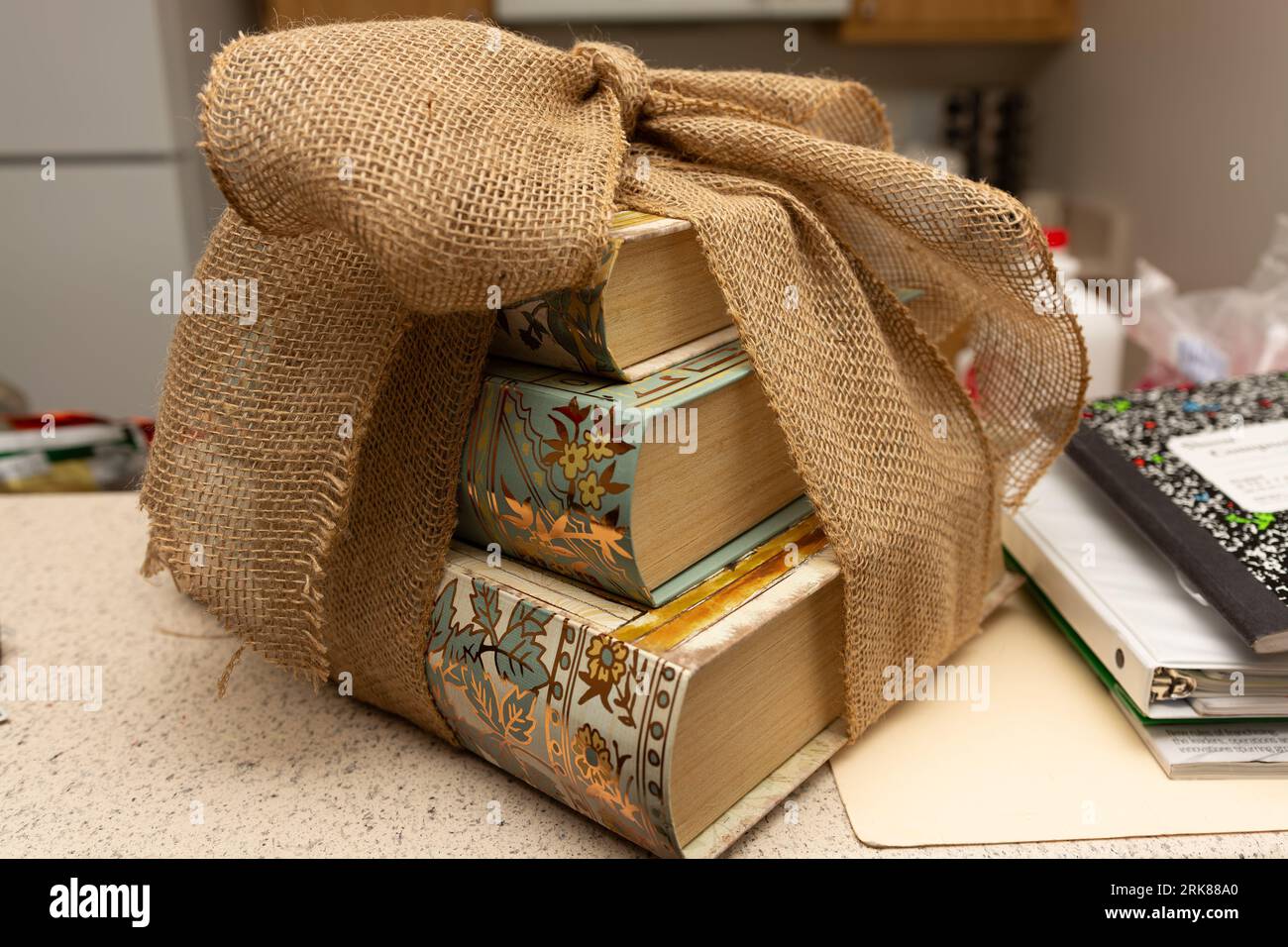 A stack of books secured with a jute ribbon bow Stock Photo - Alamy