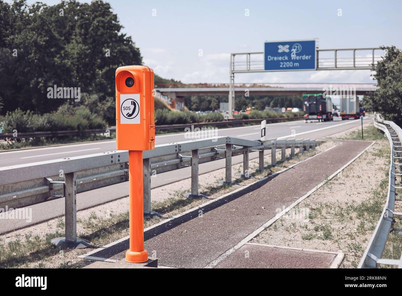 A close-up of a bright orange emergency telephone on the side of an ...