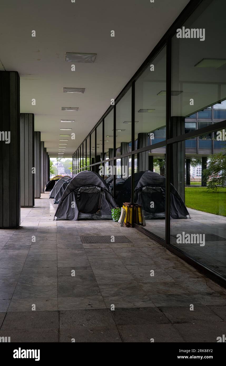A vertical of a tent camp of homeless people by an arcade in Cologne ...