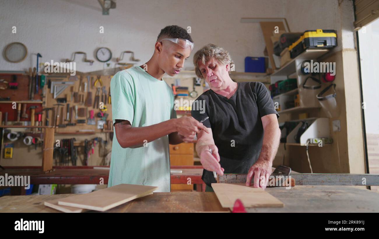Wood Sawing Scene of Carpenter Guiding Apprentice in Carpentry Workshop ...