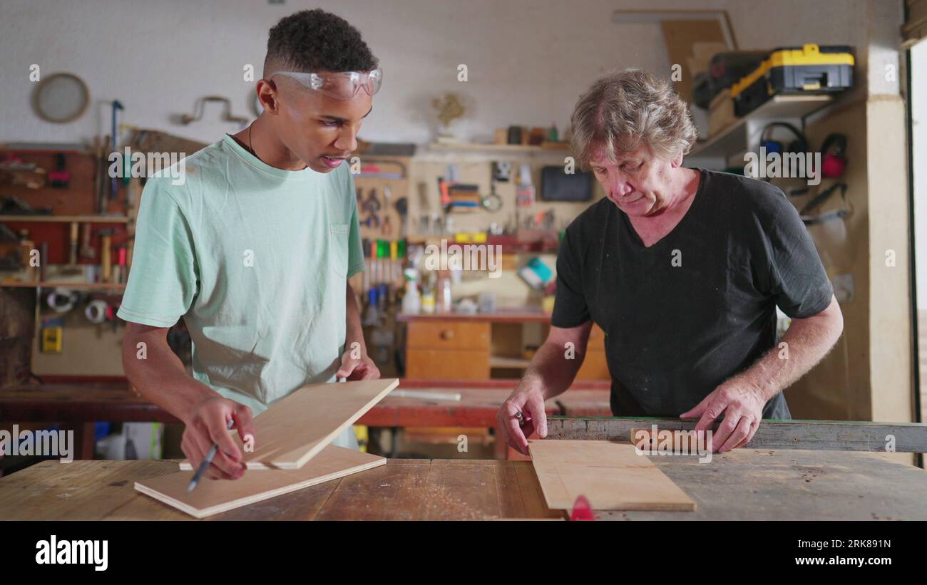 Wood Sawing Scene of Carpenter Guiding Apprentice in Carpentry Workshop ...