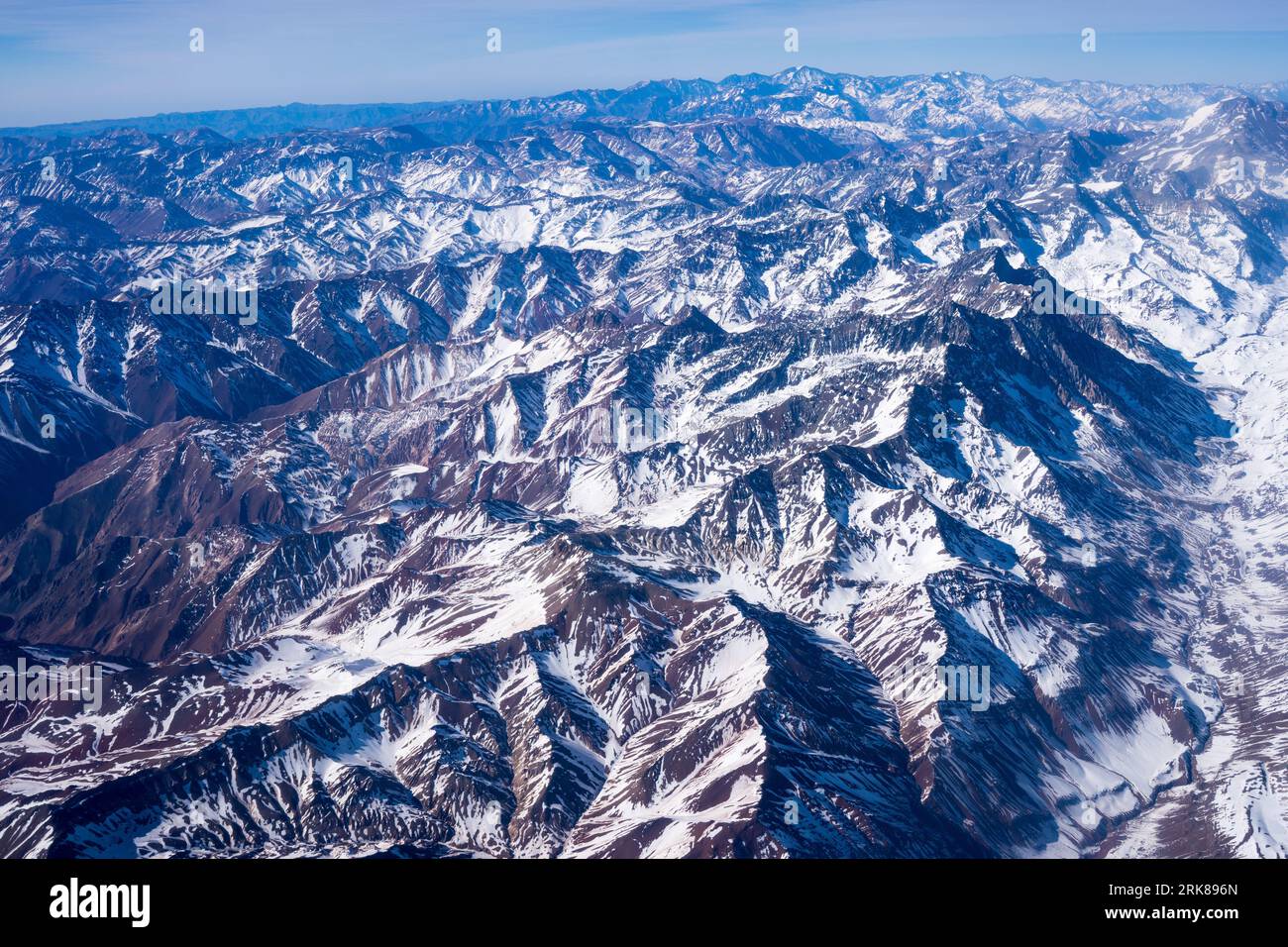 Aerial view of a mountain range from a plane, with snow-capped peaks ...
