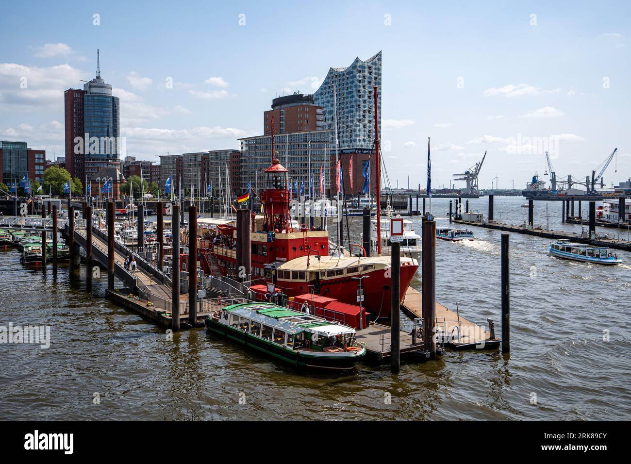 A vibrant red and white boat is moored on the tranquil surface of a ...