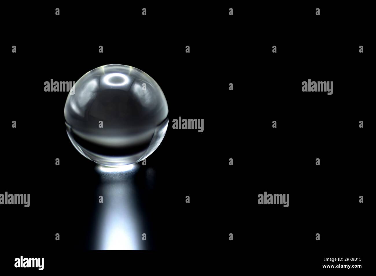 A crystal clear glass orb sitting on a solid black backdrop Stock Photo ...