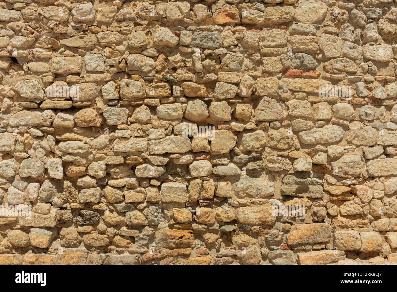 A weathered stone wall with intricate patterns and textures, creating ...
