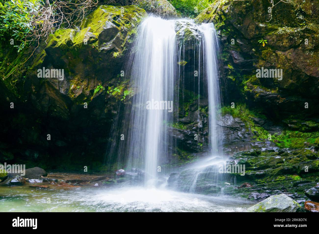 A large rock in front of a beautiful cascading Grotto waterfall Stock ...