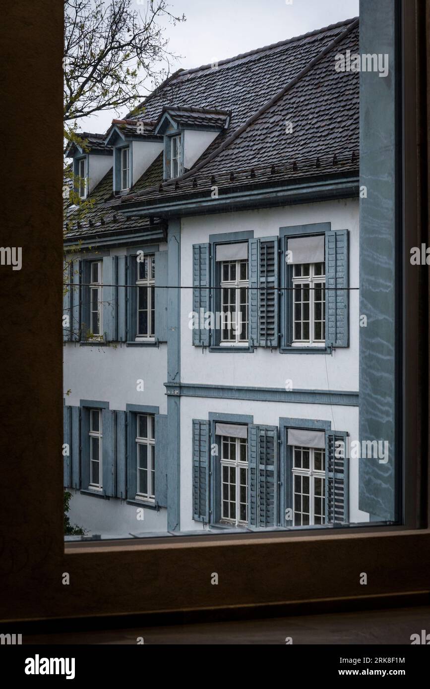 Architectural detail of historical houses seen through a huge window of ...