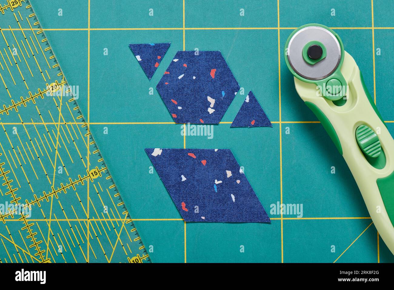 The process of cutting pieces of fabric in the shape of hexagons to ...