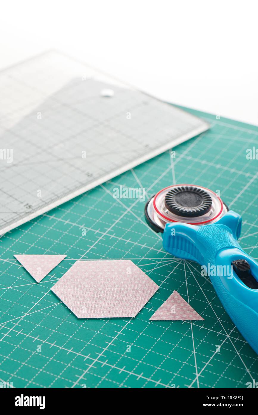 The process of cutting pieces of fabric in the shape of hexagons to ...