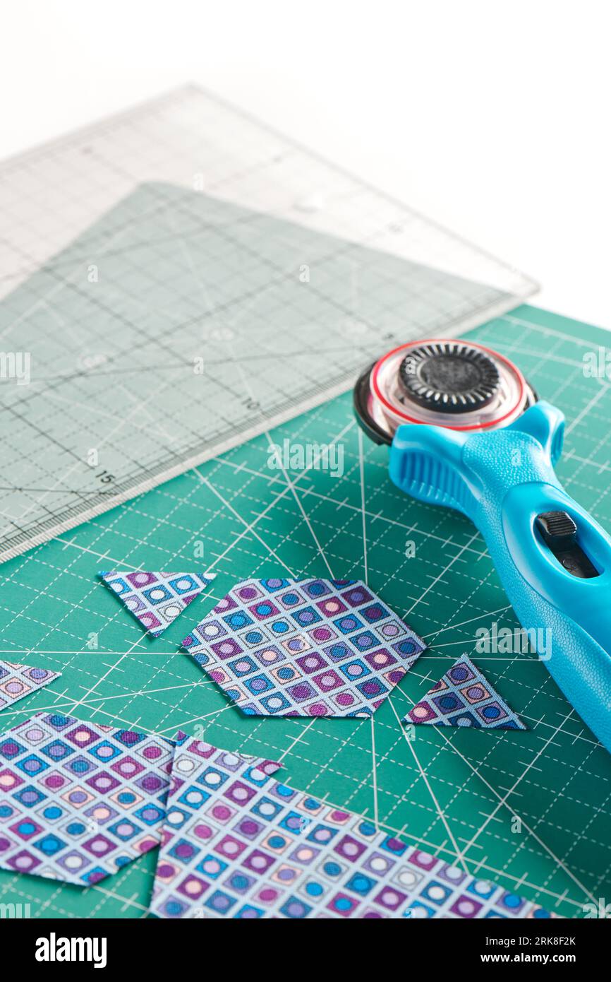 The process of cutting pieces of fabric in the shape of hexagons to ...