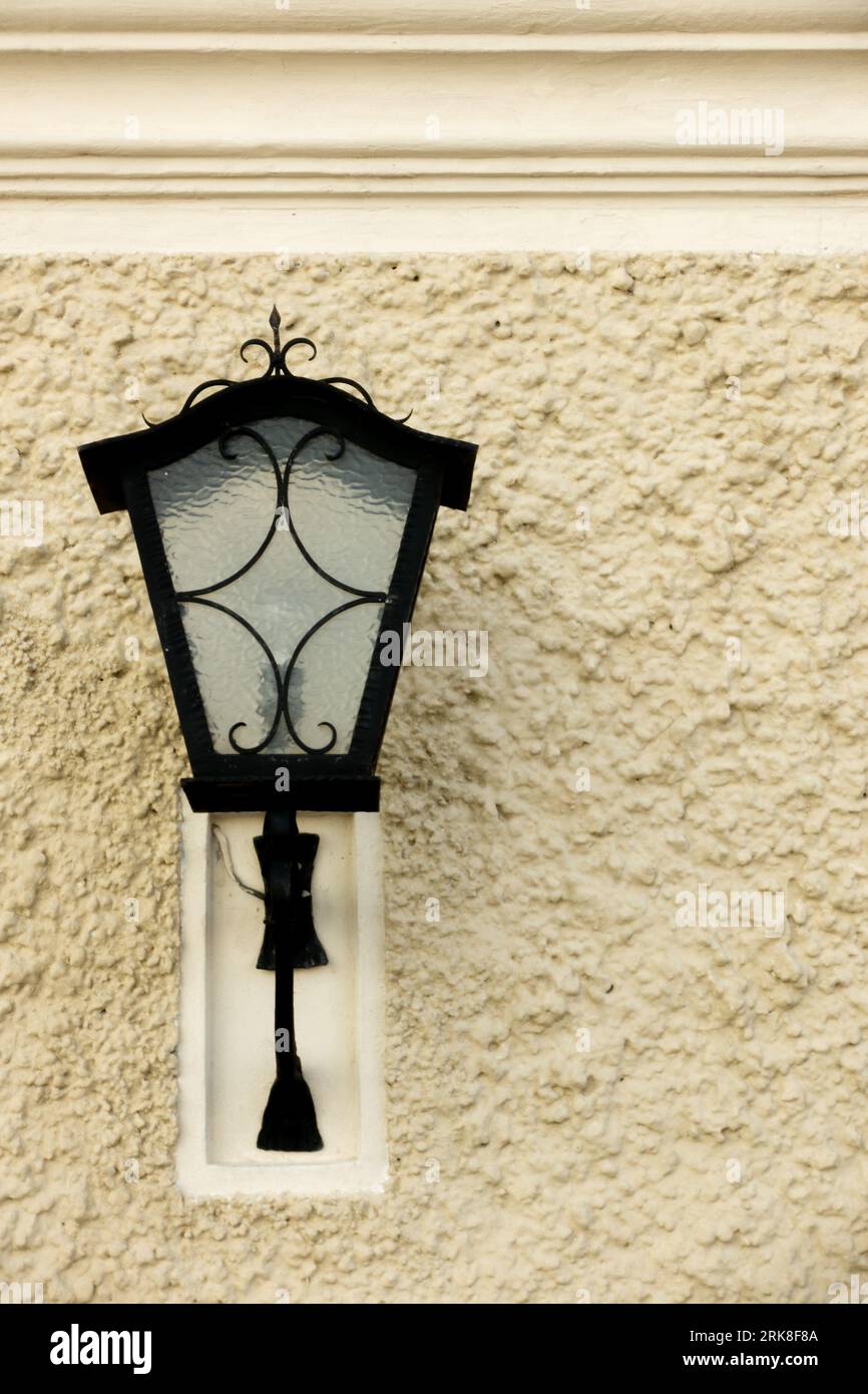 vintage old black street light on yellow plaster wall in daylight Stock ...