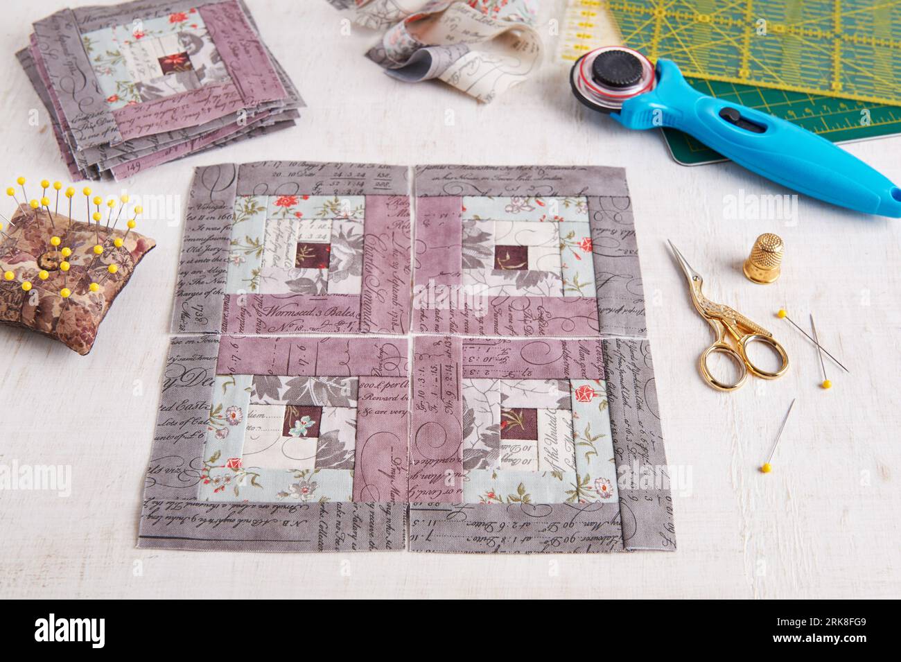 Patchwork log cabin blocks, stack of blocks, sewing accessories on ...