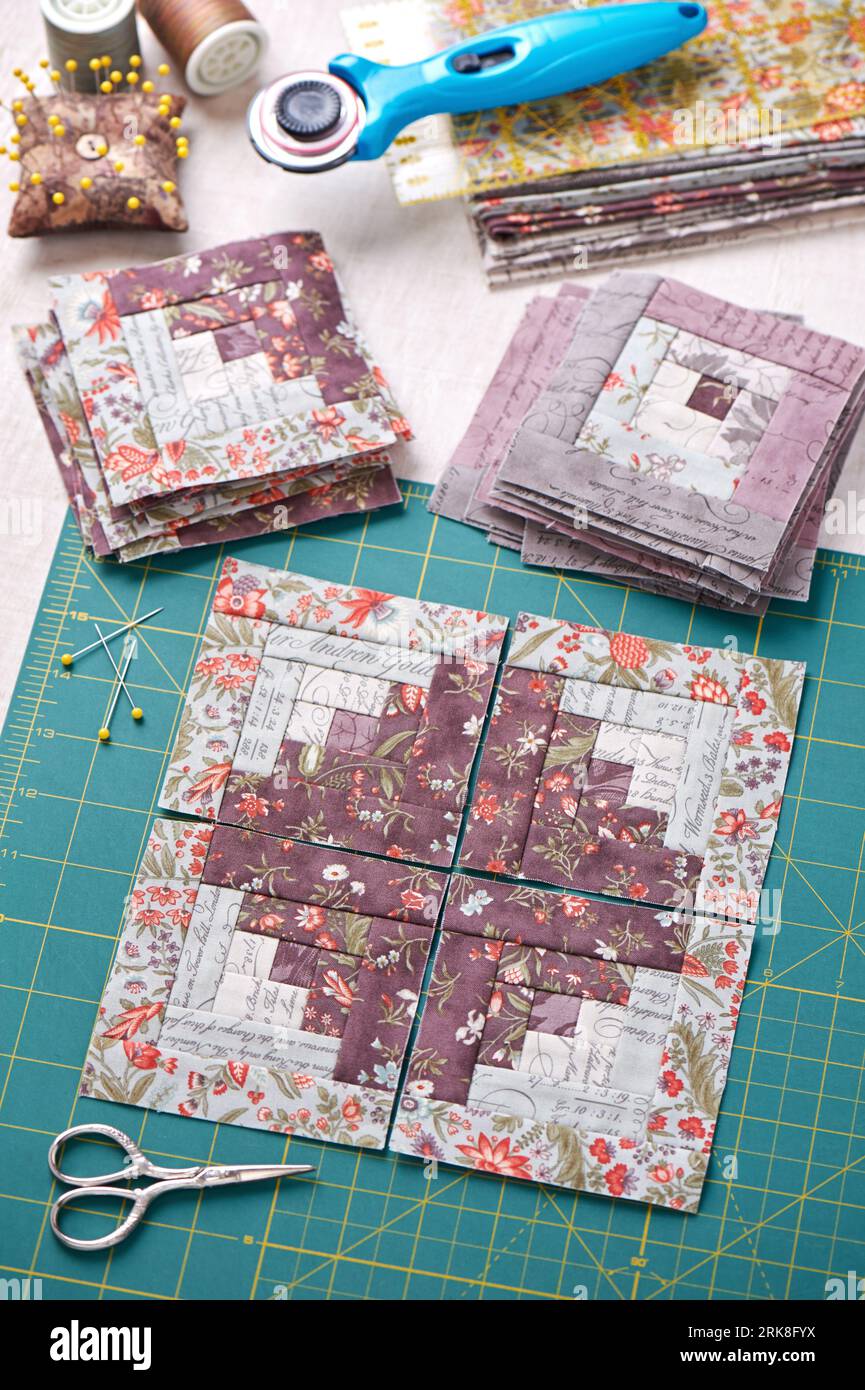 Patchwork log cabin blocks on craft mat, stack of blocks, sewing ...