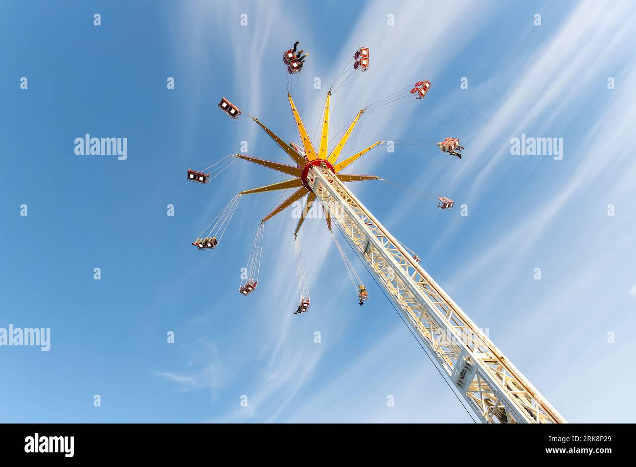 Scenic bottom view high chain swing flying carousel against blue sky ...