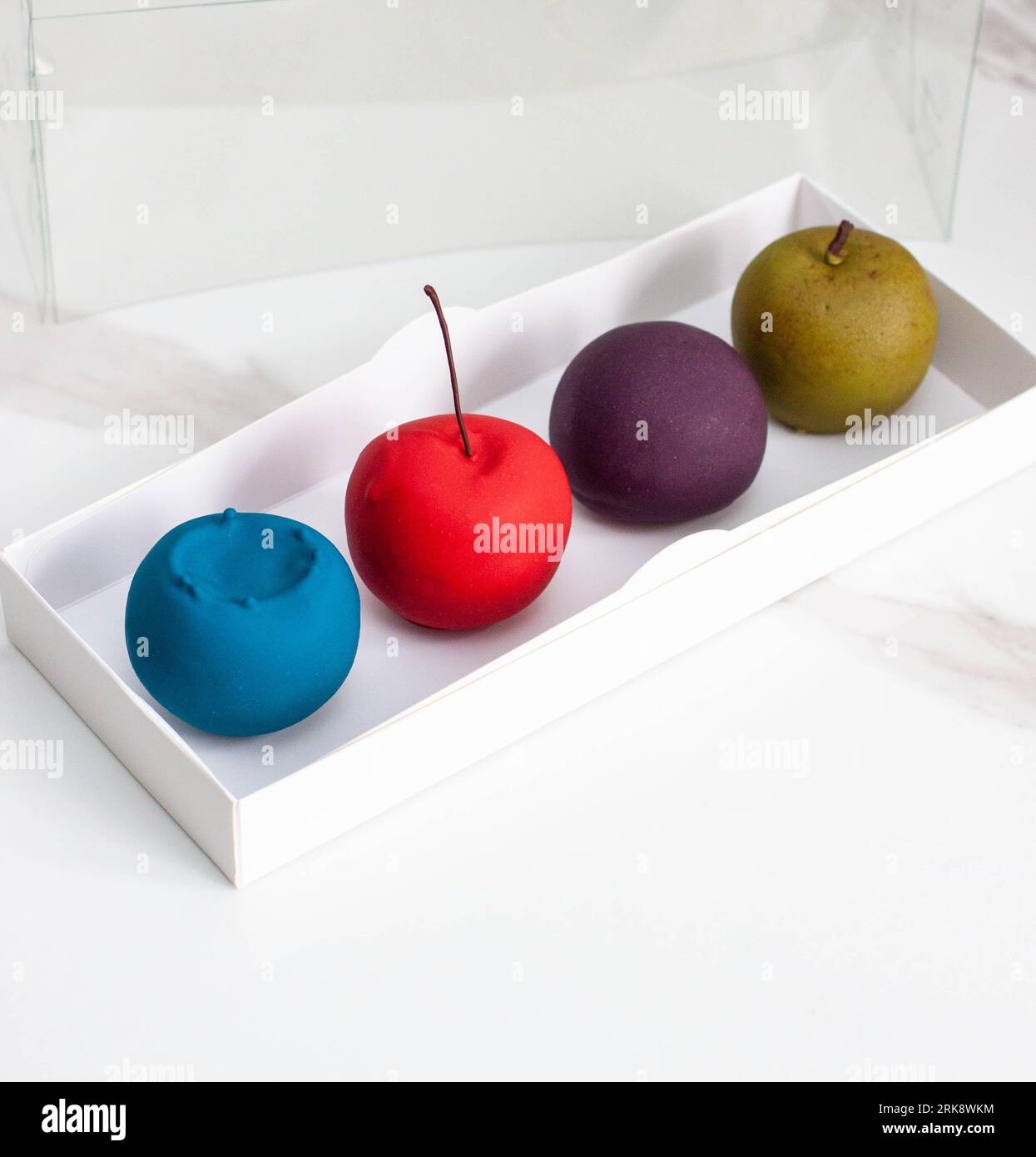 Modern realistic fruit pastries made of chocolate and mousse. Red apple ...