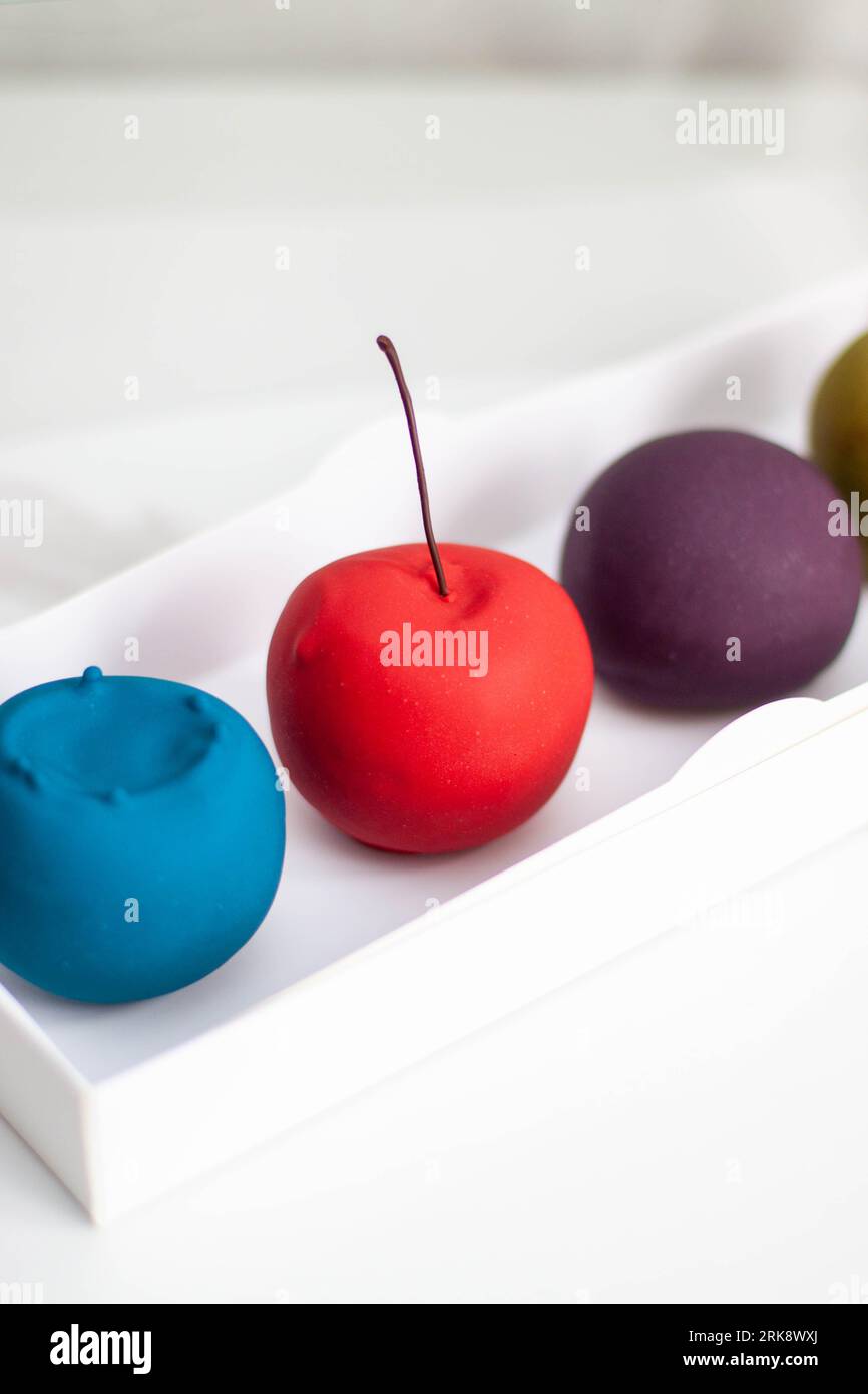 Modern realistic fruit pastries made of chocolate and mousse. Red apple ...